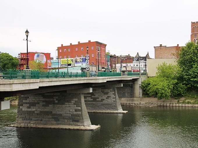 Historic Binghamton bridge spans the river like a postcard from the past, connecting charming brick buildings with timeless appeal.