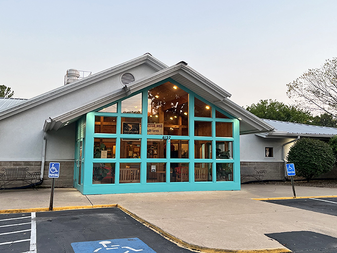 The turquoise entrance of Catfish Hole glows like a beacon at dusk, promising comfort food that'll make you forget all your worries.