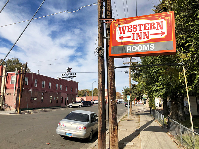 The Western Inn sign stands tall against a blue Nevada sky, promising affordable rooms in Elko's budget-friendly downtown.