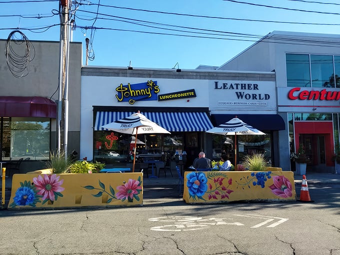 Johnny's Luncheonette greets hungry diners with blue-striped awnings and colorful flower boxes that scream "good morning" before you even step inside.