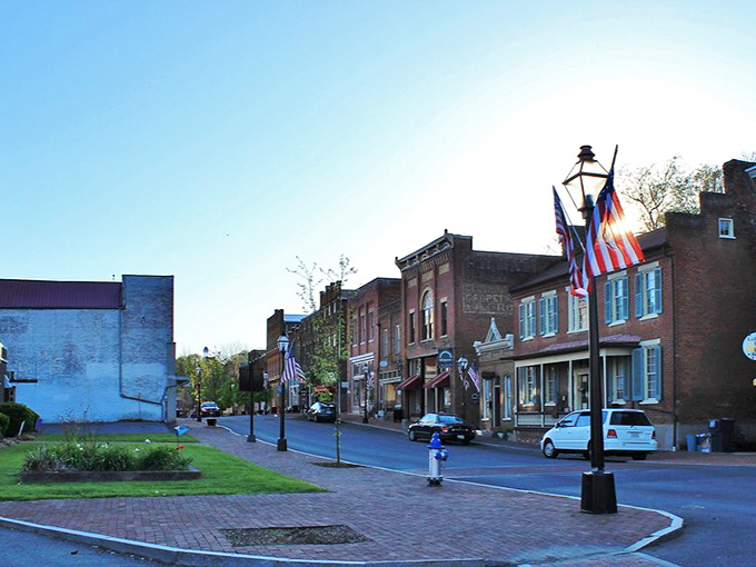 Historic Jonesborough's Main Street, where time slows down and every brick tells a story. American flags flutter above shops that have welcomed visitors for generations.