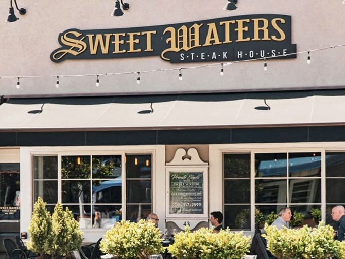 Sweet Waters' golden sign glows like a beacon for steak lovers, promising an evening of culinary bliss on Westfield's charming Elm Street.