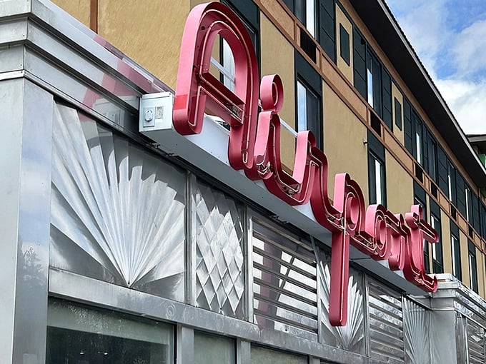 The Airport Diner's iconic neon sign glows like a beacon for hungry travelers. That red lettering promises comfort food worth landing for!