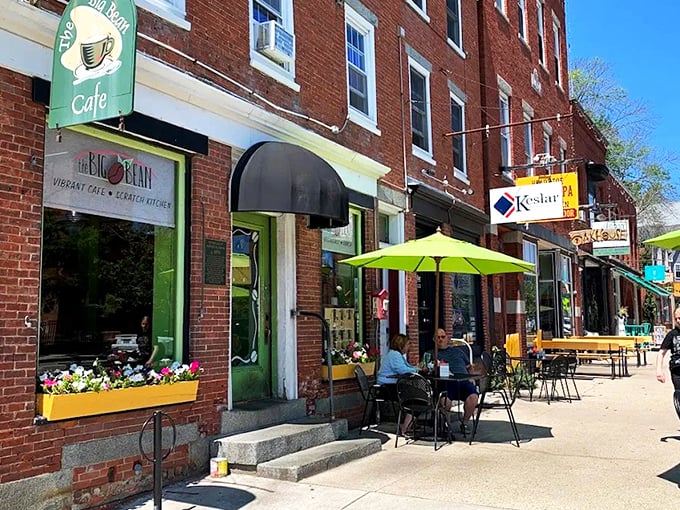 The Big Bean Caf&eacute;'s charming brick storefront beckons with its vibrant green sign and sunny outdoor seating&mdash;like a coffee-scented hug waiting to happen.