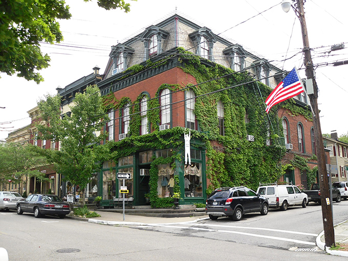 That American flag waves proudly over Cold Spring's historic buildings, where ivy climbs the walls like nature's own interior decorator.
