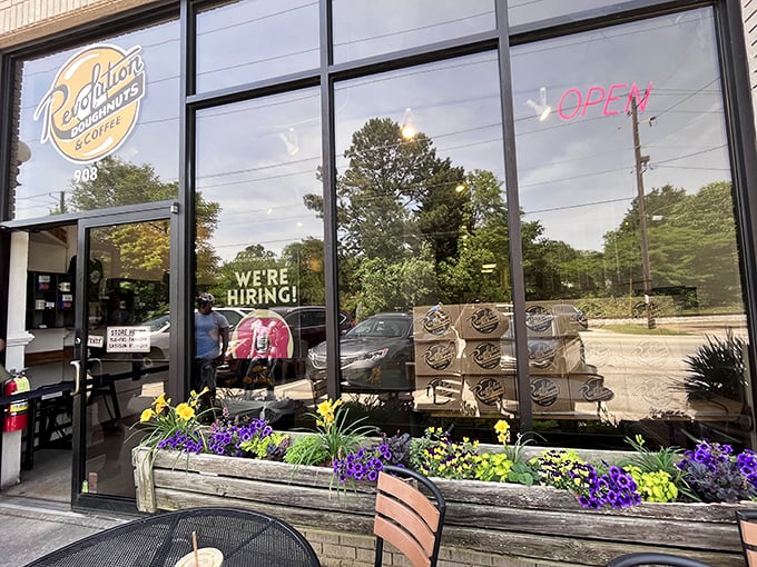 Purple flowers bloom outside while donut boxes stack inside &ndash; Nature and pastry in perfect harmony at Revolution.