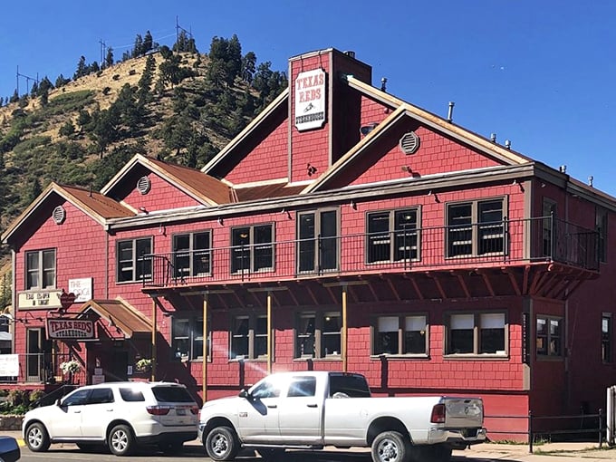 This classic red-shingled steakhouse looks straight out of a Western movie set—but the sizzling steaks inside are the real stars.