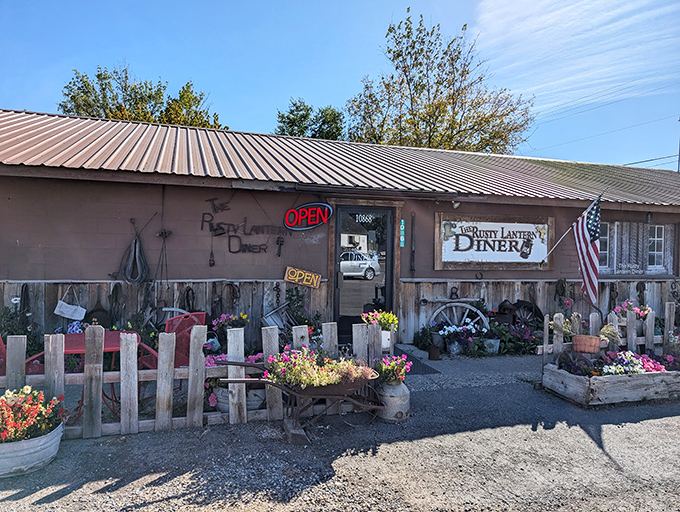 Country magic happens behind that rustic fence. Those flower beds aren't just pretty&mdash;they're a promise of homegrown goodness inside.