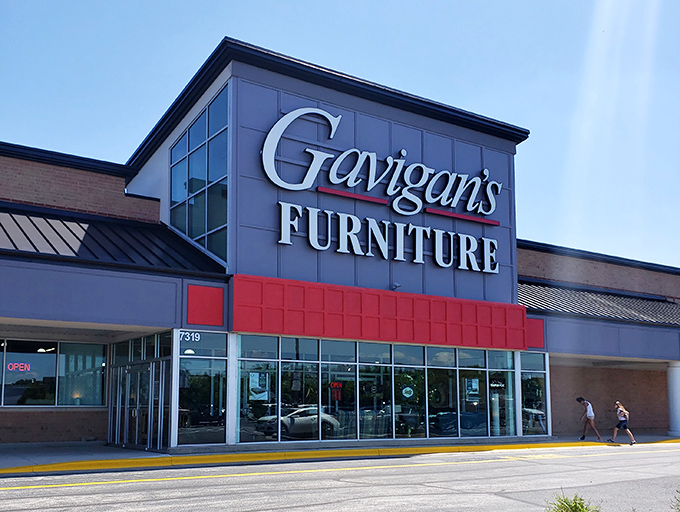 Morning light catches the Gavigan's sign, welcoming shoppers to a world where "just browsing" becomes "delivery next Tuesday." The furniture siren song begins.