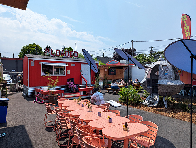 Coral tables under blue umbrellas create a cheerful oasis where strangers become friends, united by the universal language of "Oh my god, you have to try this."