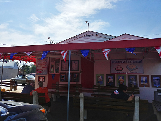 Patriotic bunting frames this temple of frozen delights, where picnic tables invite you to slow down and savor every lick.