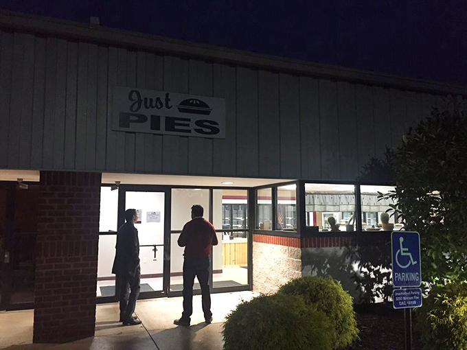Night owls line up outside Just Pies, proving that pie cravings know no time constraints. The illuminated sign beckons like a dessert lighthouse.