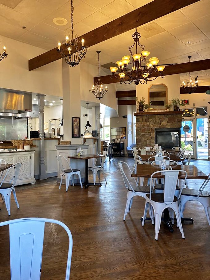 Exposed wooden beams, elegant chandeliers, and farmhouse-chic metal chairs create that perfect Instagram-worthy interior where comfort meets sophistication.