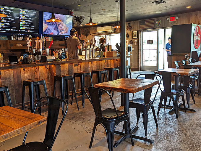 Inside, rustic industrial meets barbecue functionality with reclaimed wood, metal chairs, and an atmosphere that whispers, "Settle in, the good stuff's coming."