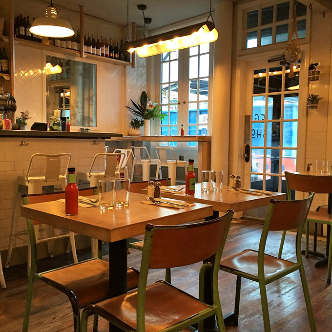 Mint-green accented chairs and warm wooden tables create that perfect "I wish my kitchen looked like this" vibe that makes lingering over coffee inevitable.