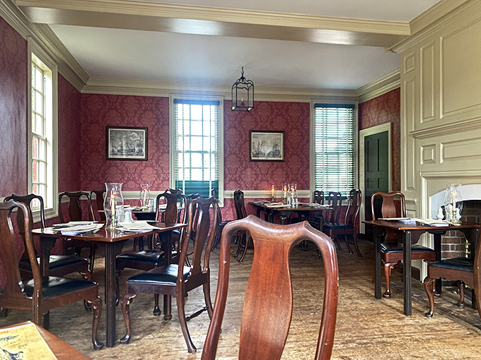 Step into a time capsule where crimson walls, polished mahogany, and Queen Anne chairs transport you to an era when dinner conversation never included smartphone notifications.