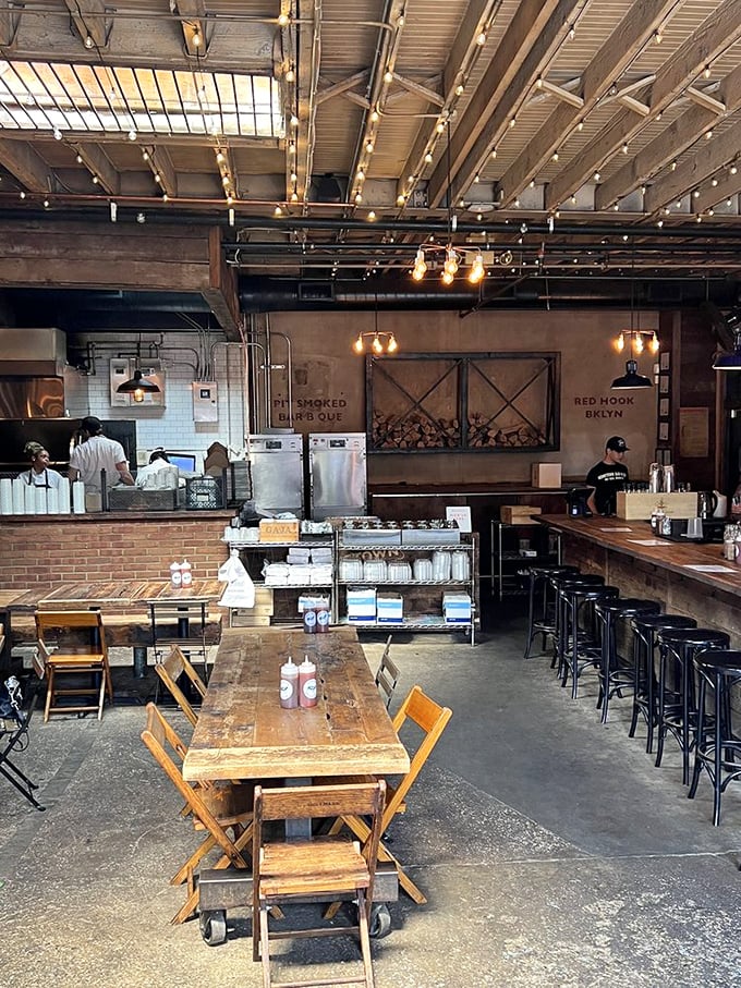 Industrial chic meets Southern comfort in this dining room where string lights twinkle above wooden tables that have witnessed countless barbecue epiphanies.