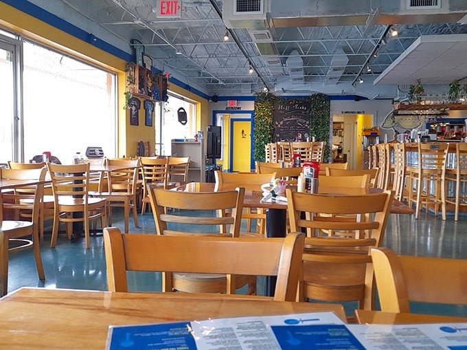 Sunshine streams through windows into a dining room where wooden chairs and bright blue floors create the perfect backdrop for morning epiphanies over coffee.