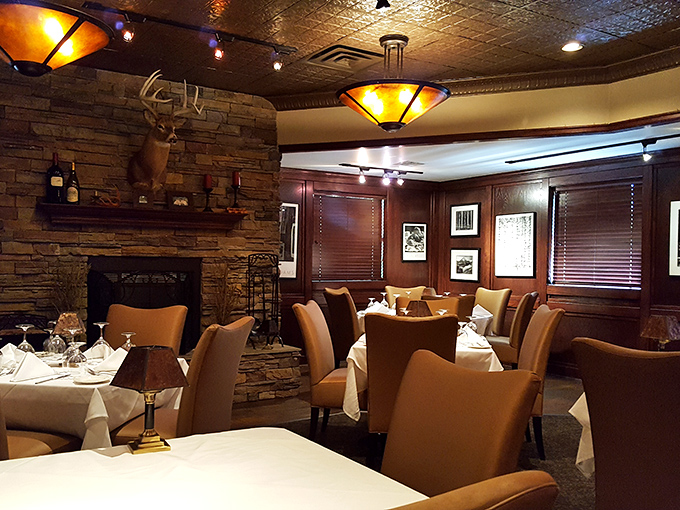 Warm amber lighting, leather chairs, and that magnificent stone fireplace create the perfect backdrop for serious steak contemplation.