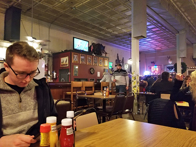 Inside Big Ed's, neon beer signs cast their glow over conversations that matter: family, weather, and whether to order the 16oz or 24oz cut tonight.