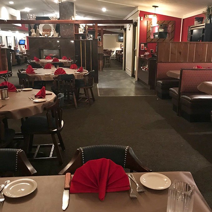 Classic steakhouse ambiance done right: dim lighting, comfortable seating, and those signature red napkins folded with surprising elegance.