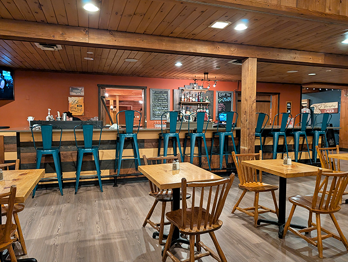 The bar area's rustic-meets-modern vibe, complete with turquoise metal stools, offers the perfect perch to contemplate life's most important question: brisket or ribs?