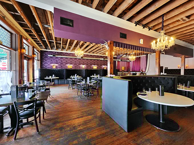 Step inside to discover elegant chandeliers illuminating purple walls and exposed beams. The contrast between rugged and refined sets the perfect stage for culinary drama.