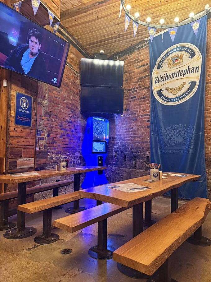 Rustic wooden tables and benches beneath circular chandeliers create the perfect communal dining atmosphere. The exposed brick walls practically whisper German drinking songs. Photo