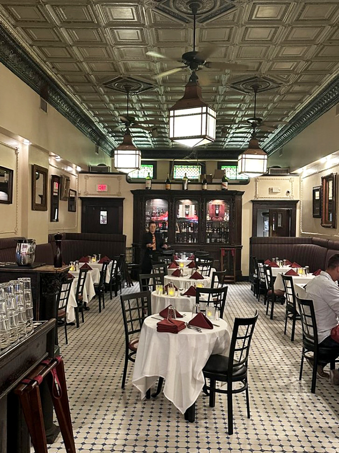 That tin ceiling has witnessed more Kansas City secrets than a confessional. The checkerboard floor practically hums with jazz rhythms of decades past.