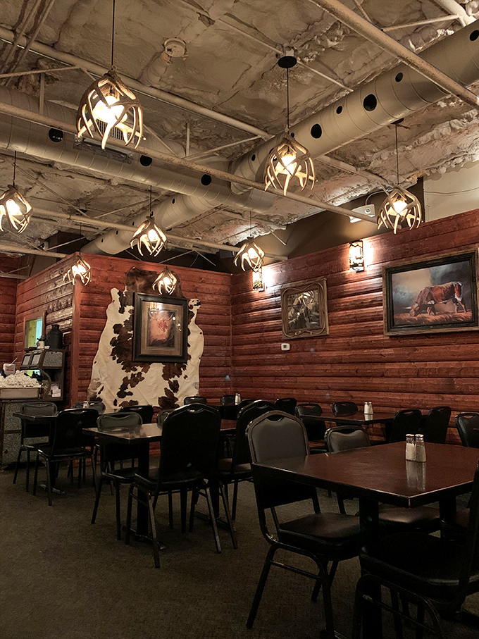 Antler chandeliers cast a warm glow over wood-paneled walls, creating the perfect atmosphere for serious meat consumption. Cowhide accents complete the authentic Western vibe.