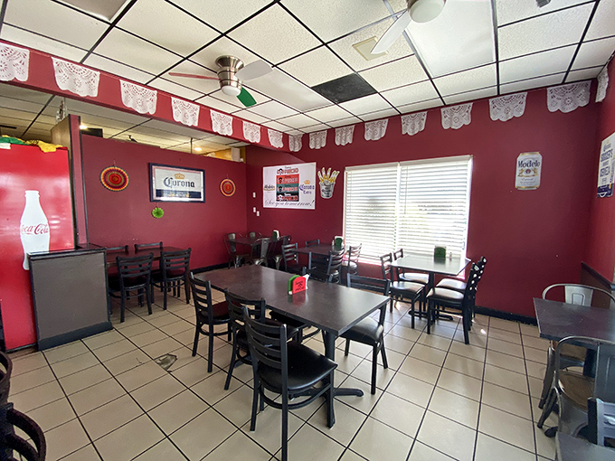 Inside, vibrant red walls and papel picado banners create the perfect backdrop for the serious business of authentic taco enjoyment.