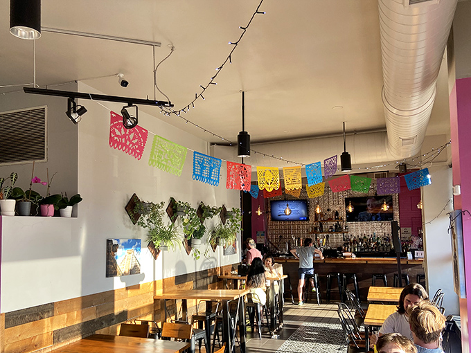 Colorful papel picado flags dance overhead while industrial-chic meets Mexican warmth in this thoughtfully designed space that feels like a perpetual fiesta. 