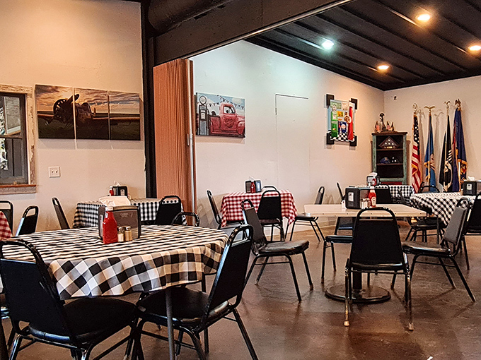 Black and white checkered tablecloths create a classic diner atmosphere where conversations flow as freely as the coffee, under the watchful gaze of American flags.