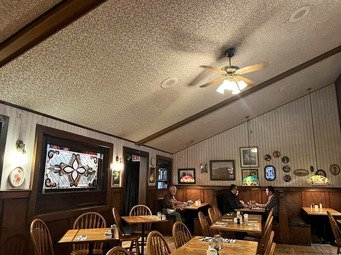 Warm wood paneling, stained glass accents, and ceiling fans spinning lazily overhead&mdash;this is what breakfast dreams are made of. The kind of place where coffee refills appear magically.