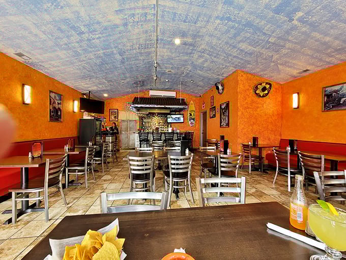 Vibrant orange walls and pressed tin ceilings create an atmosphere that's both festive and cozy, transporting you straight to Mexico.