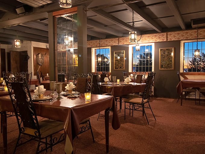 Dining room ambiance that whispers "Game of Thrones dinner party" without the unfortunate wedding outcomes. Those wrought iron chandeliers cast the perfect glow for feasting.