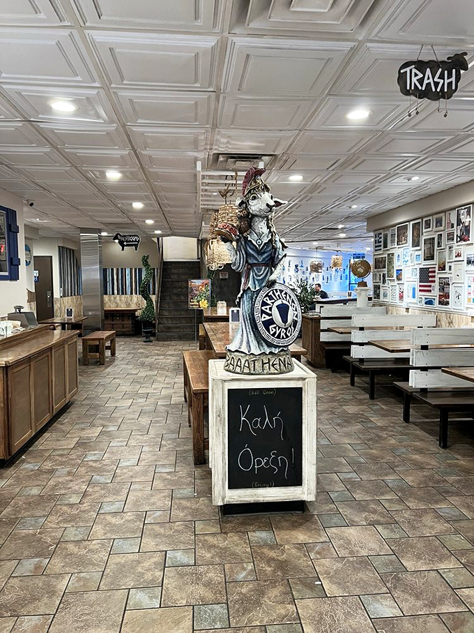 Inside, a whimsical statue greets diners with "&Kappa;&alpha;&lambda;ή Ό&rho;&epsilon;&xi;&eta;" (good appetite), standing guard over tables where countless gyro dreams have come true.