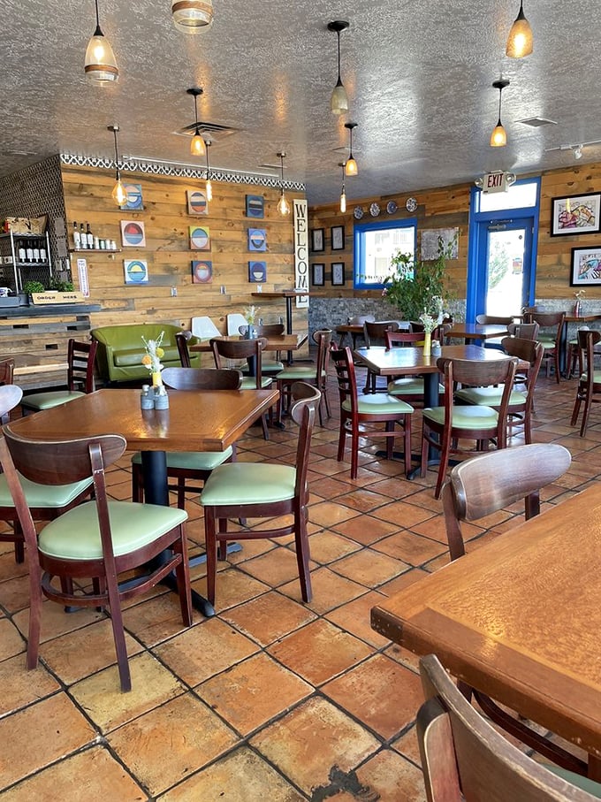 Warm wooden walls, pendant lighting, and those signature blue accents create a space that feels both cozy and transporting—Greece meets New Mexico in perfect harmony.