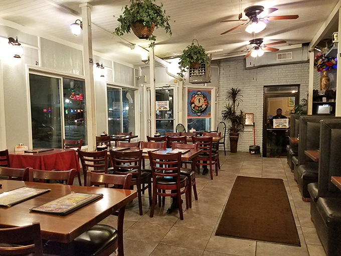 Cozy simplicity with a touch of greenery. The warm interior offers a welcoming retreat where ceiling fans gently stir the aromas of spices and grilled meats.