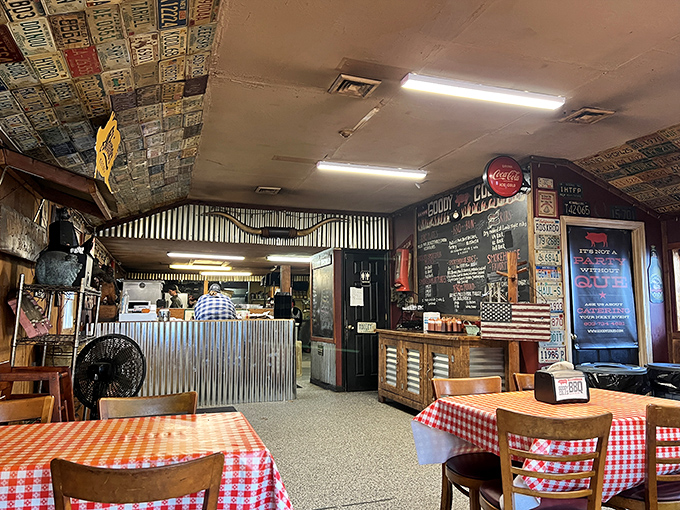 License plates from across America create a patchwork ceiling above classic red-checkered tables. It's not just decoration&mdash;it's a road map of barbecue pilgrims. 