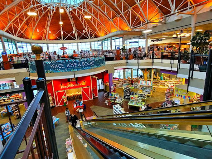 Warm light fills the vaulted ceiling as you descend toward a vibrant children&rsquo;s area, discovering endless stories and cozy corners.