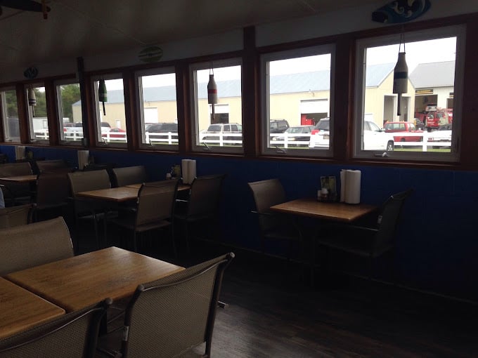 Simple wooden tables beneath nautical-blue walls create the perfect backdrop for the seafood drama about to unfold on your plate.