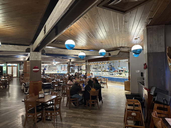 Nautical blue pendant lights hover like jellyfish above diners, creating the perfect atmosphere for seafood indulgence.