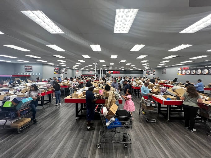 Retail chaos theory in its purest form. Dozens of modern-day prospectors sift through mountains of merchandise, each hoping to strike gold in these crimson bins.