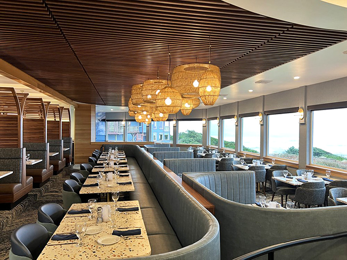 Basket pendant lights cast a golden glow over ocean-blue booths, creating the perfect backdrop for seafood that deserves its own spotlight.