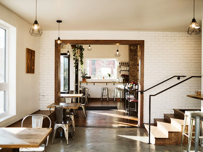 Where industrial meets cozy &ndash; white brick walls, wooden accents, and those geometric pendant lights create the perfect backdrop for your caffeine revelation.