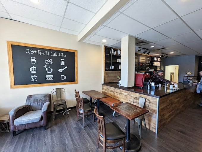 Rustic meets modern in this cozy interior where wooden tables, leather chairs, and a chalkboard menu create the perfect "stay awhile" vibe.