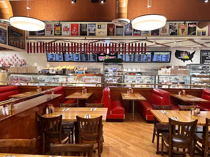 The deli interior feels like a time machine to mid-century Manhattan&mdash;red booths, wooden tables, and Broadway memorabilia creating an atmosphere as authentic as the food.