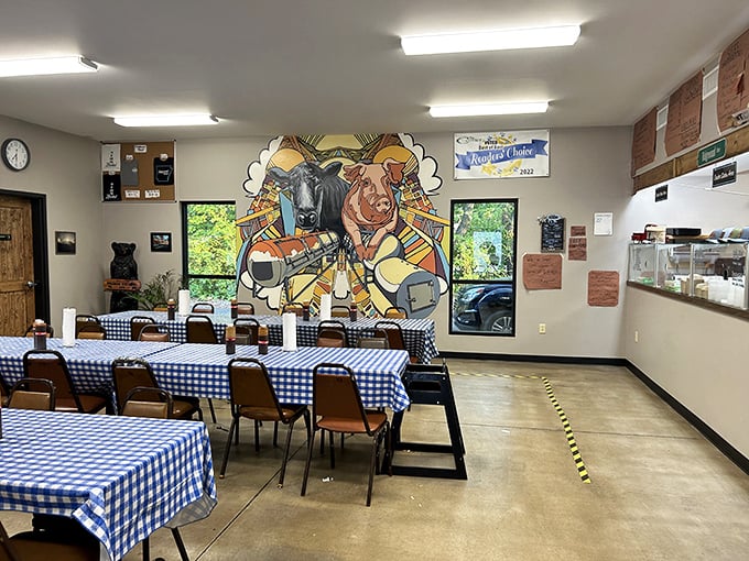 Blue checkered tablecloths and a vibrant mural featuring the stars of the show—cow and pig—create the perfect backdrop for the smoky drama about to unfold on your plate.