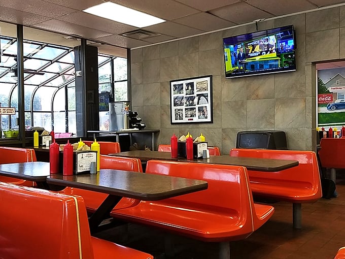 Those flame-red booths aren't just seating—they're front-row tickets to a South Carolina culinary institution where conversations and condiments flow freely.